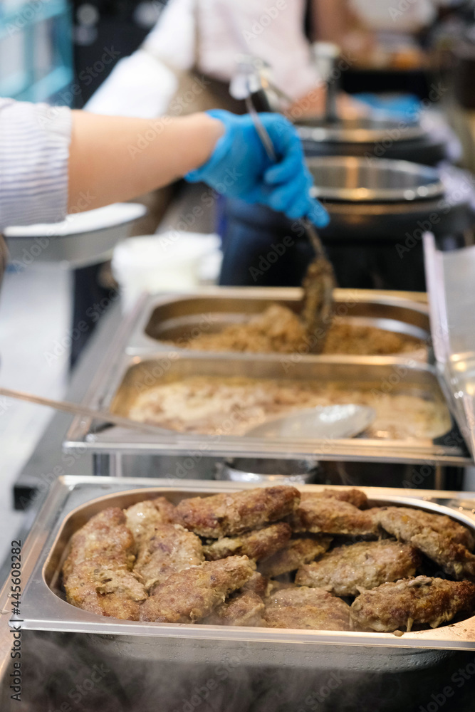 Meat dishes on the food distribution line in the self-service dining ...