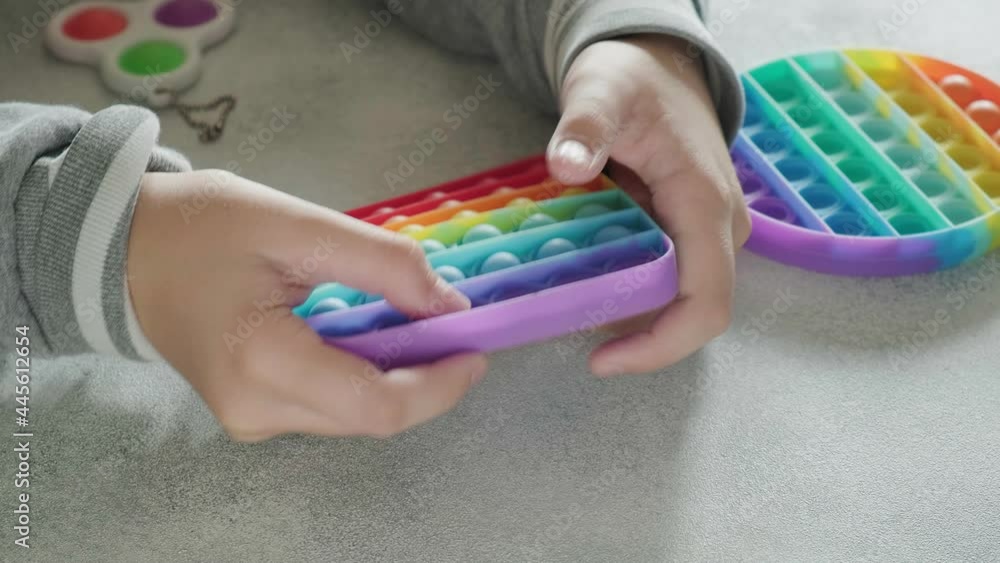child playing pop it fidget toys, closeup on hands. unrecognizable ...