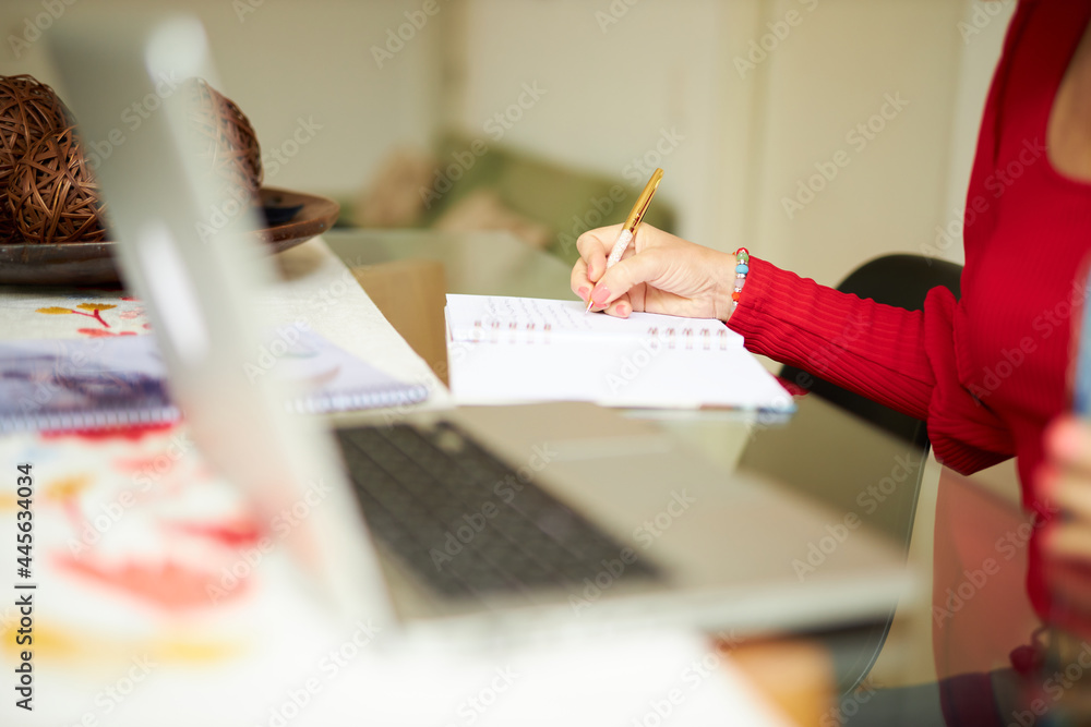 mujer trabajando en casa y anotando en una libreta con un lapicero ...