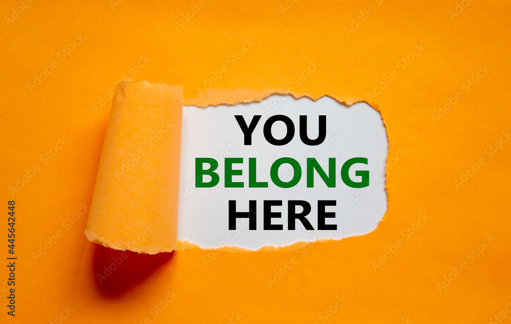You belong here symbol. Words 'You belong here' appearing behind torn ...