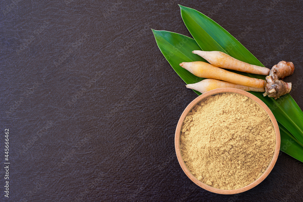 Fingerroot with finger root herbal powder in wooden bowl isolated on ...