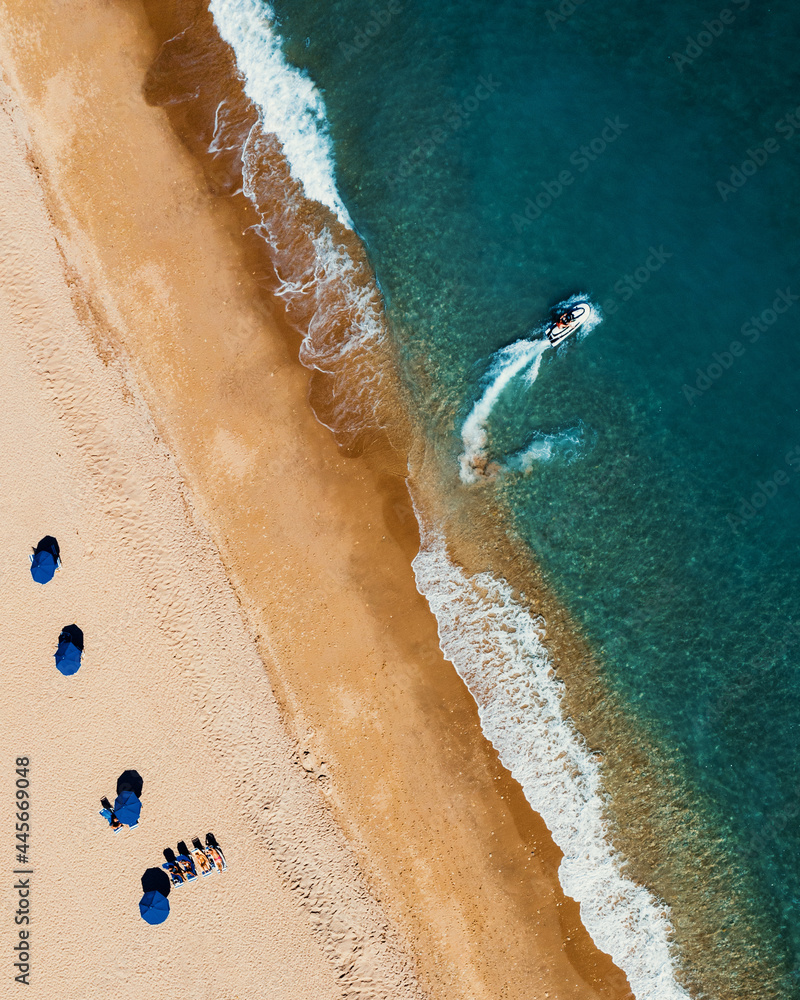 epic overhead capture of summer beach with jet ski and people laying ...