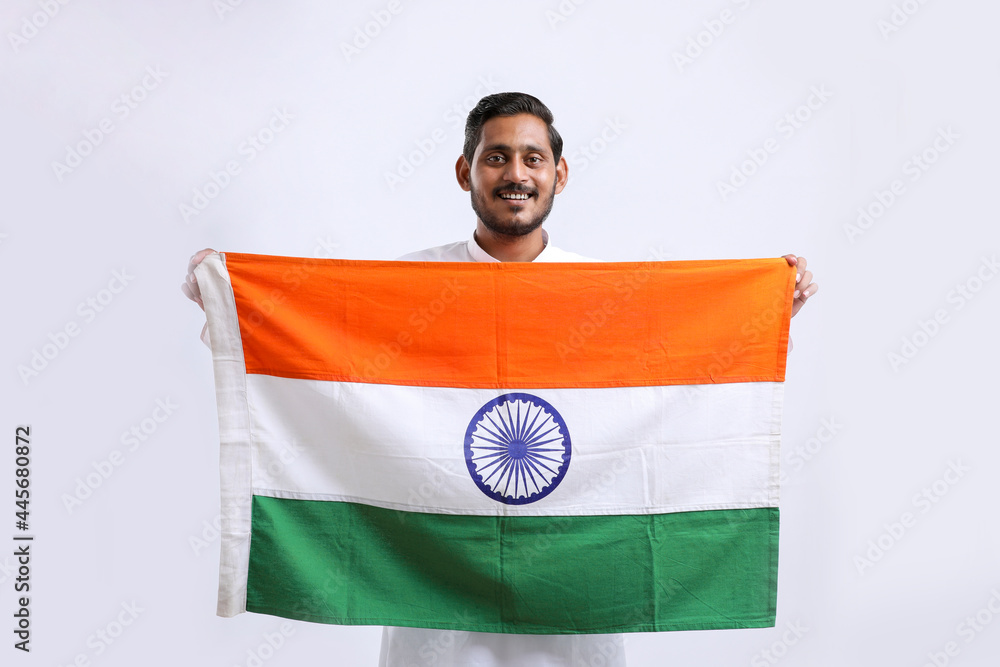 Young indian man holding indian national flag in hand over white ...