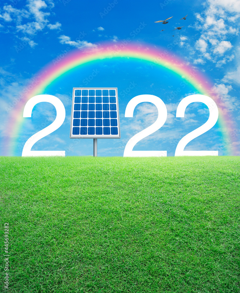 2022 white text with solar cell on green grass field over rainbow ...