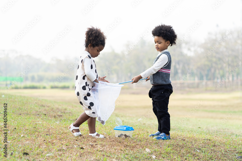 African American little boy and girl holding dustpan and collecting ...