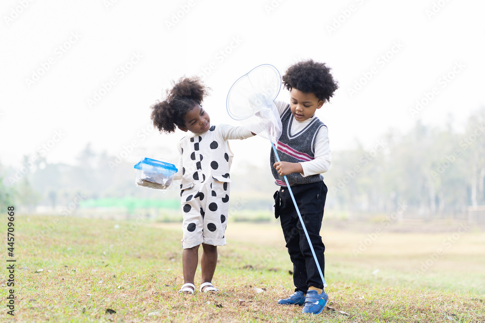 African American little boy and girl holding dustpan and collecting ...