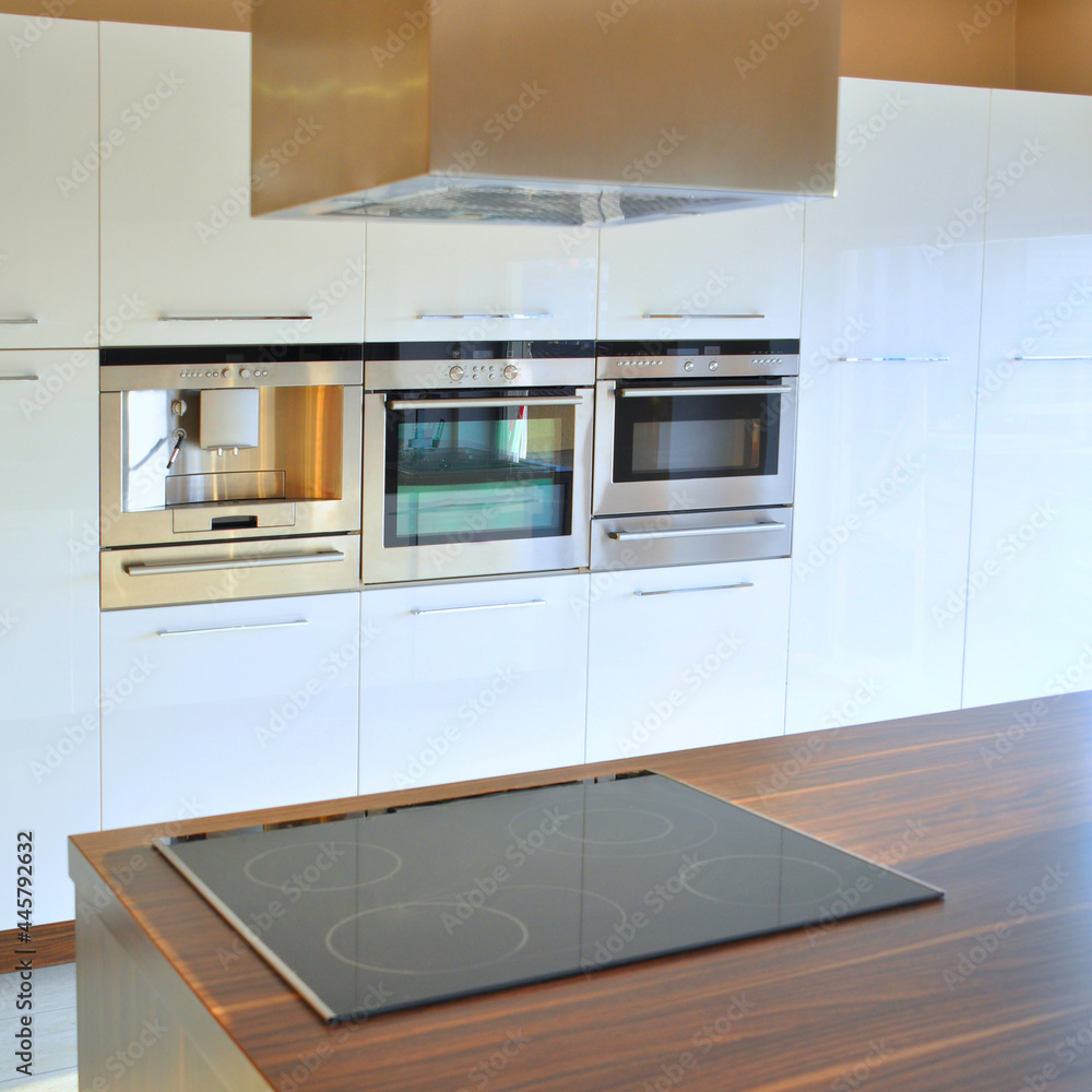 Foto de Interior of modern kitchen equipment, white and walnut cabinets ...