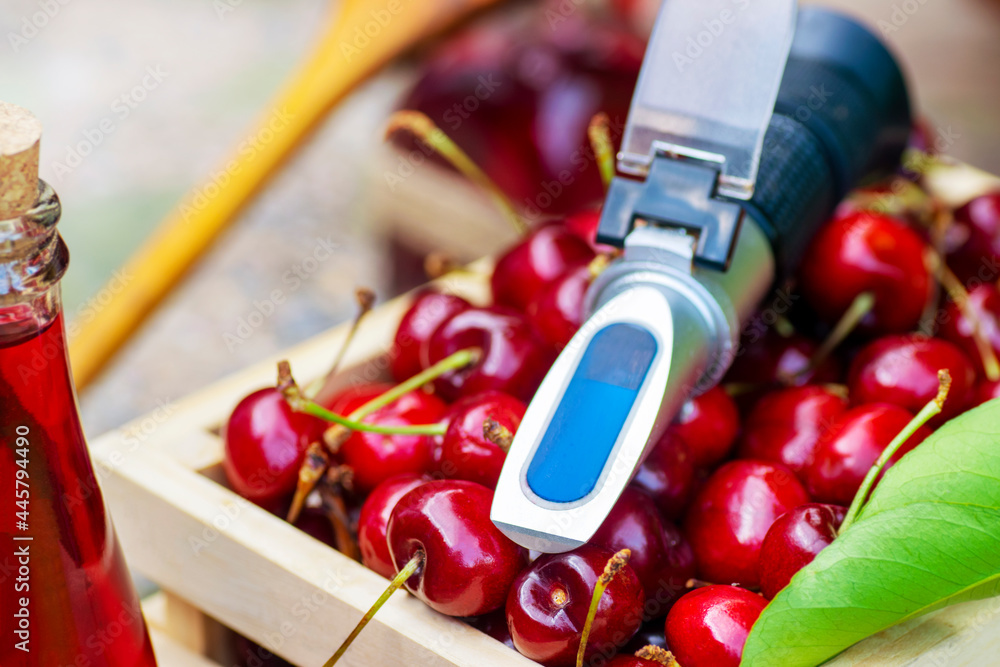 Refractometer to measure Brix graduation over a wood box with Cherries ...