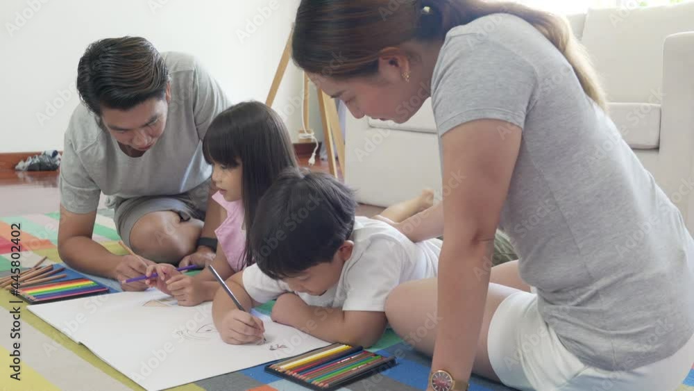 Asian family parents with little daughter and son lying on the floor ...