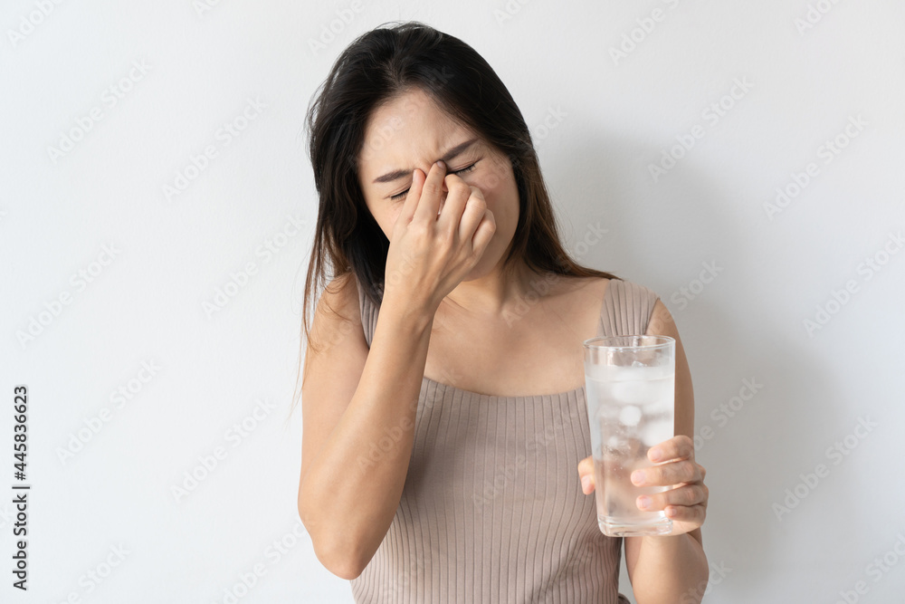 Portrait of young Asian woman has brain freeze after drink iced water ...