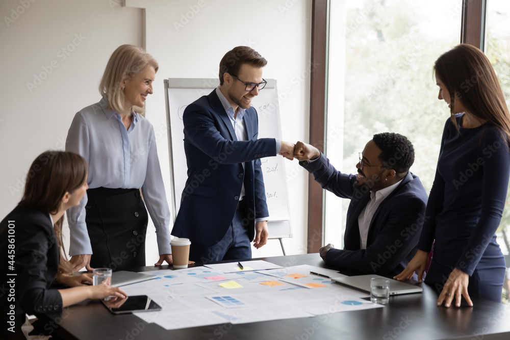 Foto Stock Happy excited diverse male office buddies making fist bump ...