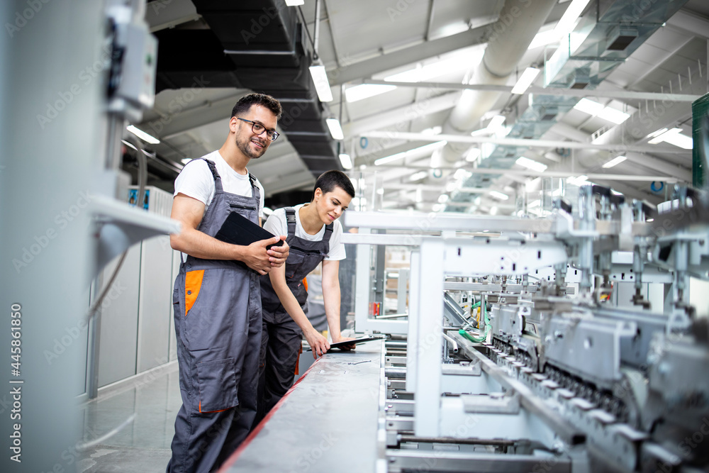 Production line workers controlling manufacturing process of modern ...
