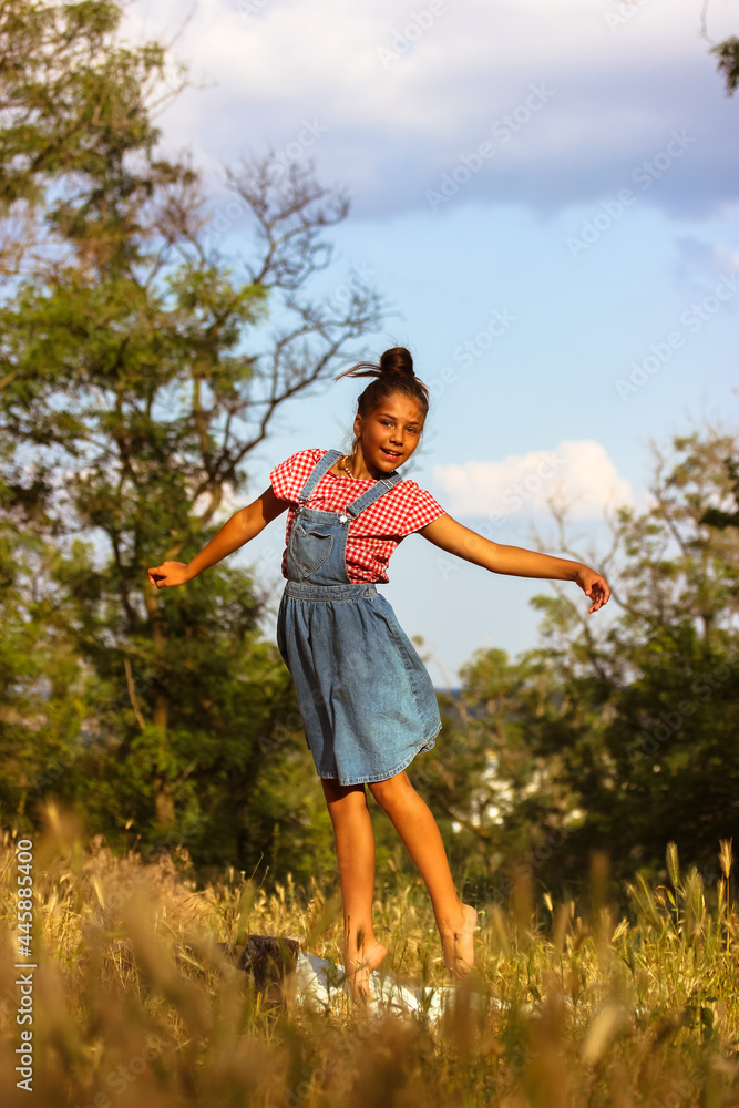 Young ballerina, gymnast model on summer vacation. A beautiful teenage mestizo girl in a denim ...