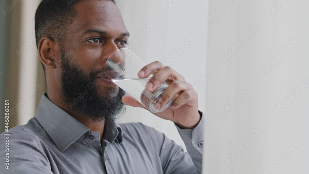Young adult mixed race Healthy man holding glass drinking pure cold ...