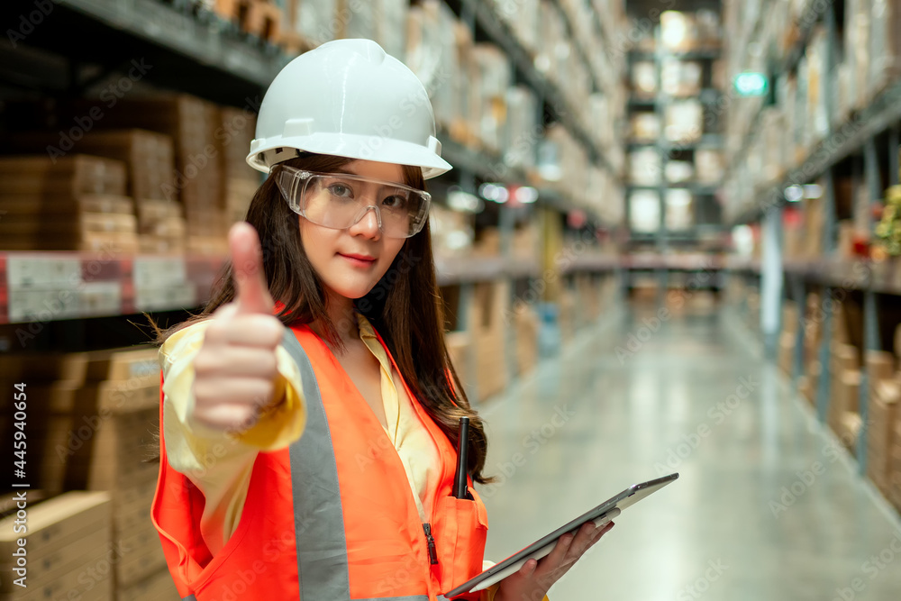 Female warehouse worker inspecting a warehouse in a factory. Wear a ...