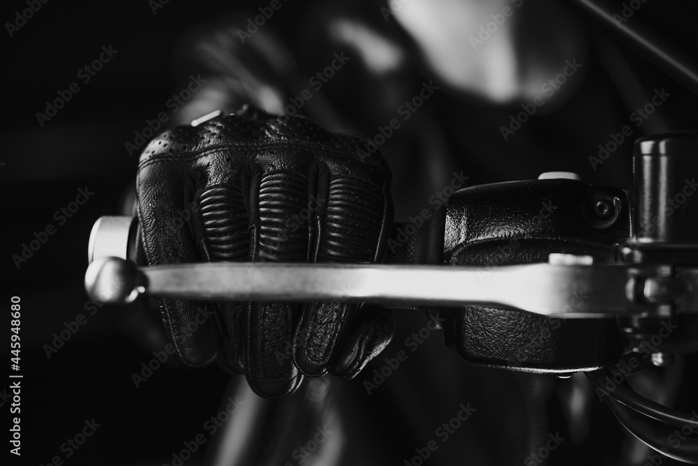 Motorcyclist hand wearing leather gloves twists accelerometer lever ...