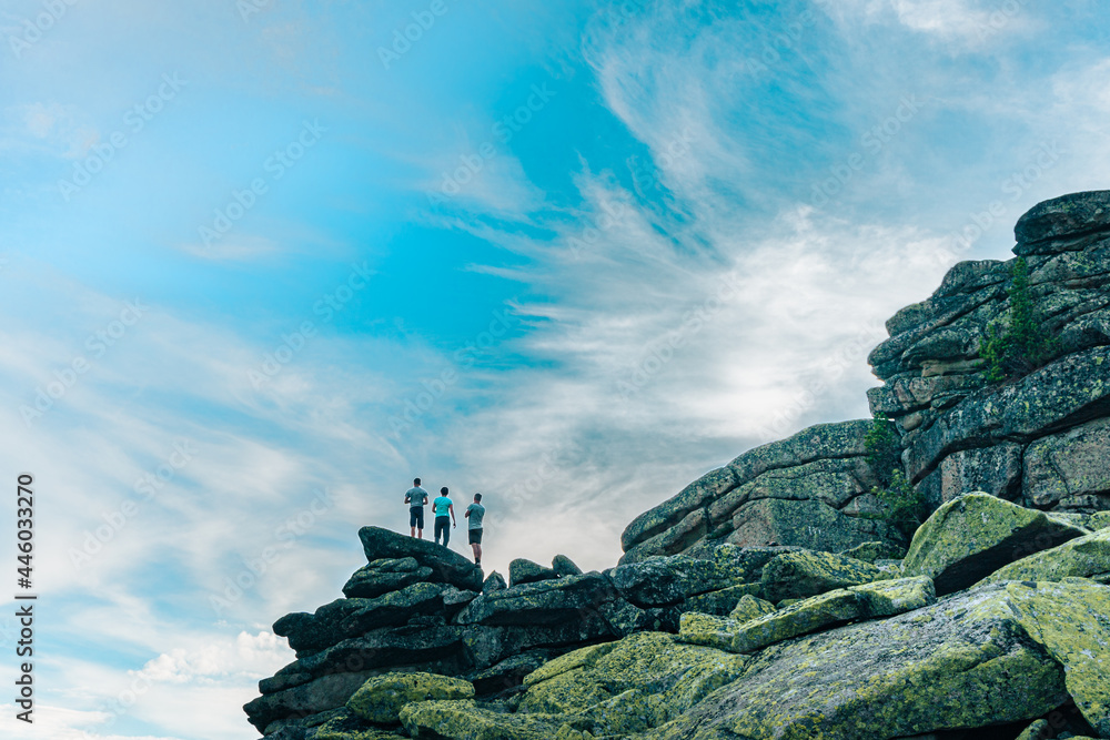People climb and stand on the rock on the top of mountain range and ...