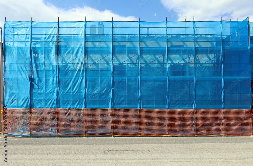 Scaffold plastic sheeting covering a facade under refurbishment, a ...