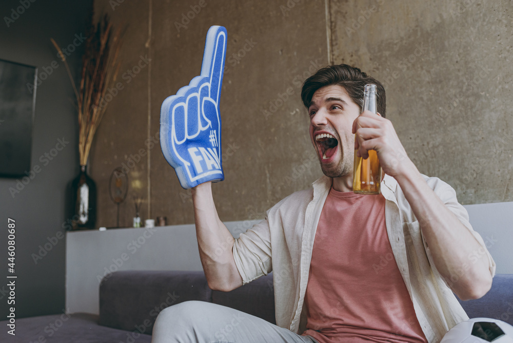 Young overjoyed man 20s fan wearing casual clothes fan foam glove ...
