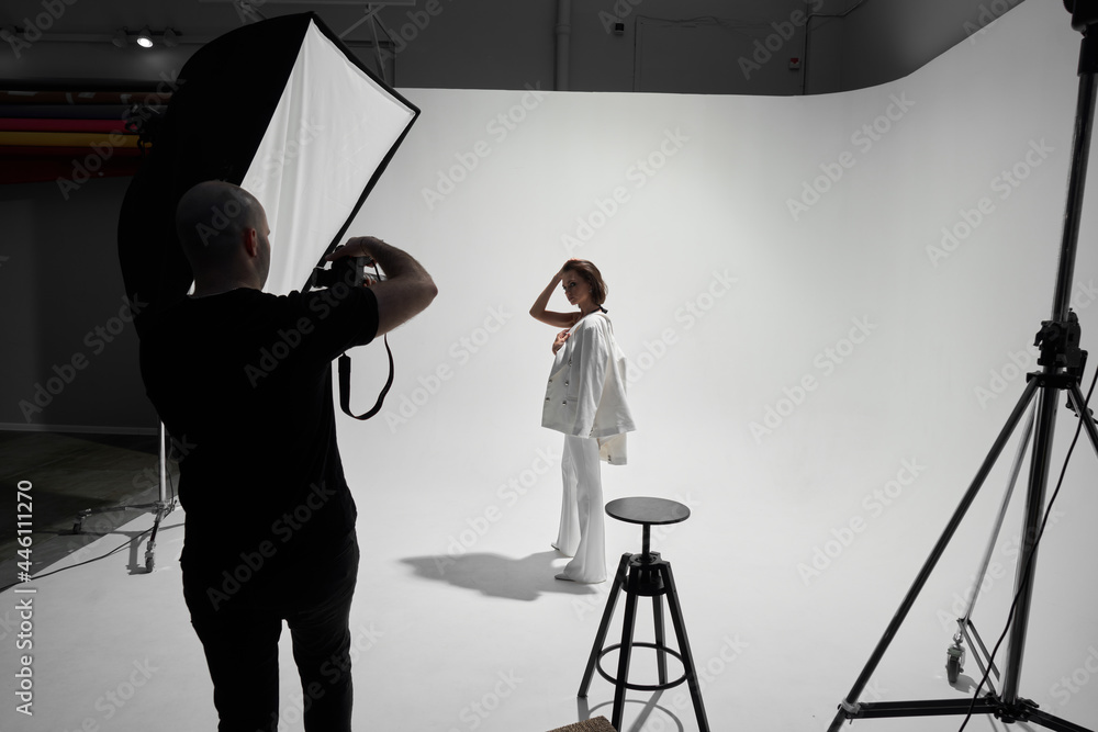 Fashion photography in a photo studio. Professional male photographer ...