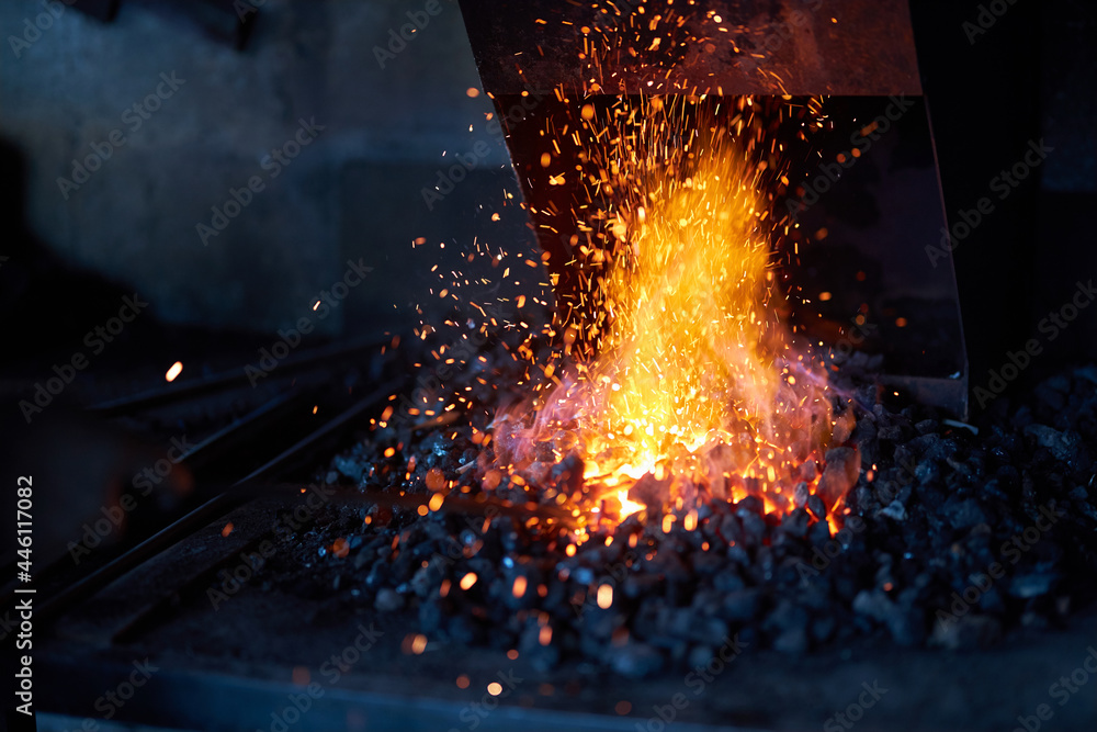 Red hot metal in burning fire preparing for forging process at workshop ...