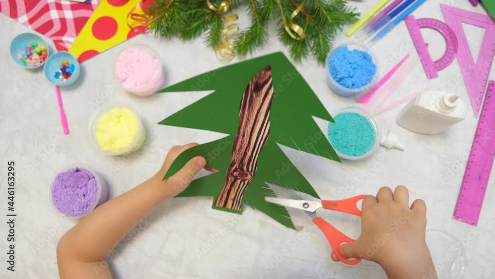 Stockvideon Child makes a greeting card Christmas paper and foam ...