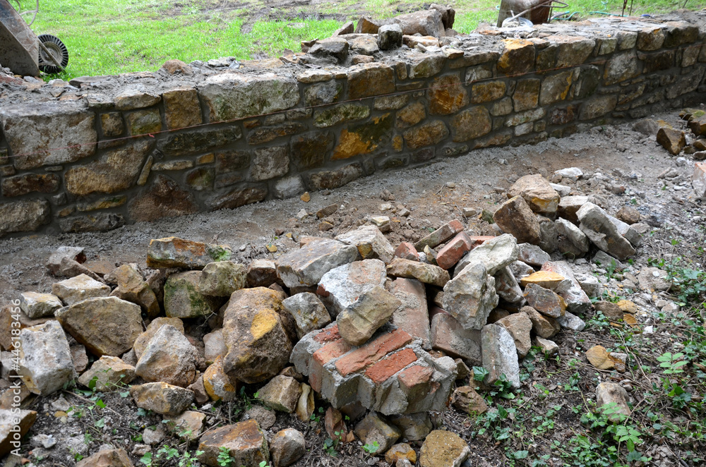 an old stone wall is being reconstructed between the two plots. the ...
