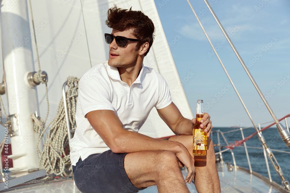 Young man drinking beer on his yacht in sea Stock Photo | Adobe Stock