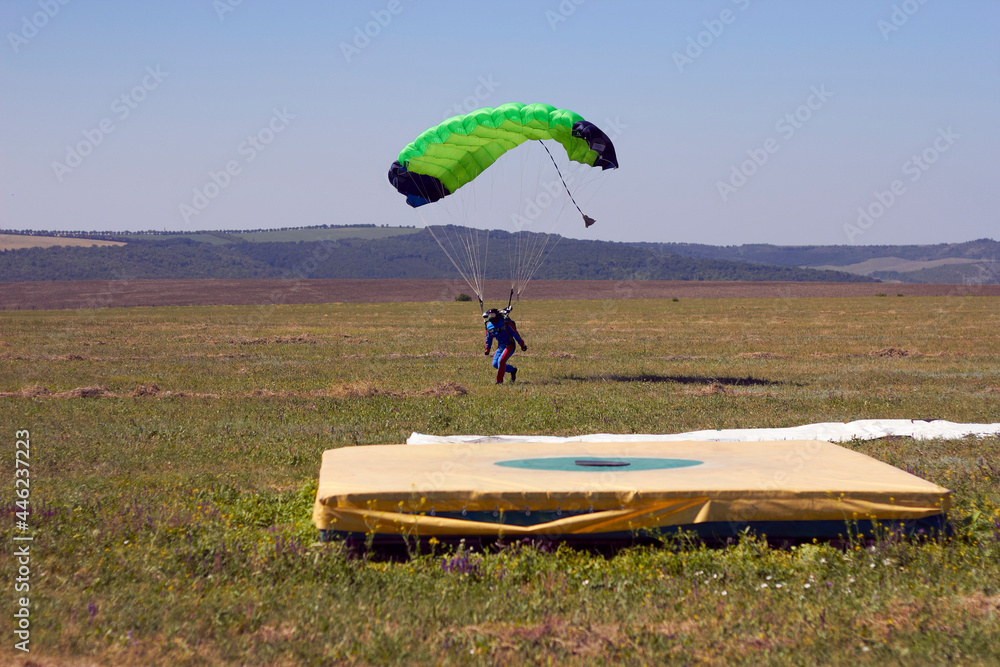 Foto de Landing of paratrooper with a professional parachute in the ...
