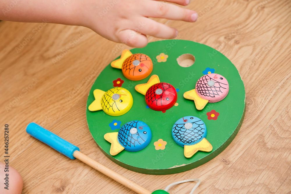 Let's go fishing. Wooden fishes and fishing rod with magnet on the tip ...