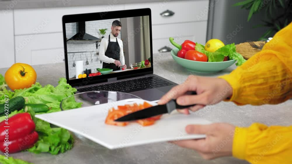 Housewife in kitchen knives sliced tomato from cutting board into salad ...