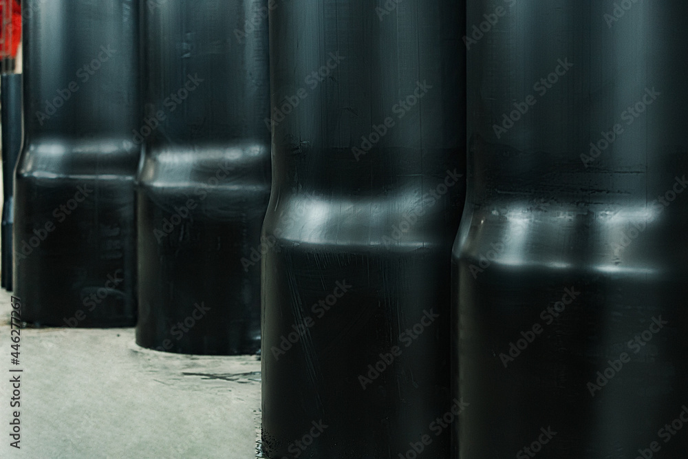 black cylindrical plastic pipes of different diameters are in stock ...