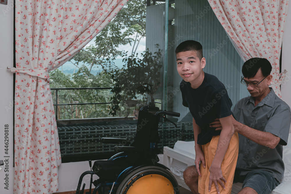 Asian disabled child standing practice with father and wheelchair in ...