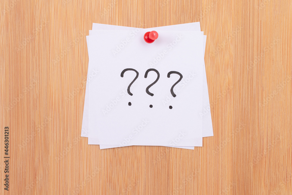 White Sticky Notes with Three Question Marks Pinned to the Wooden ...