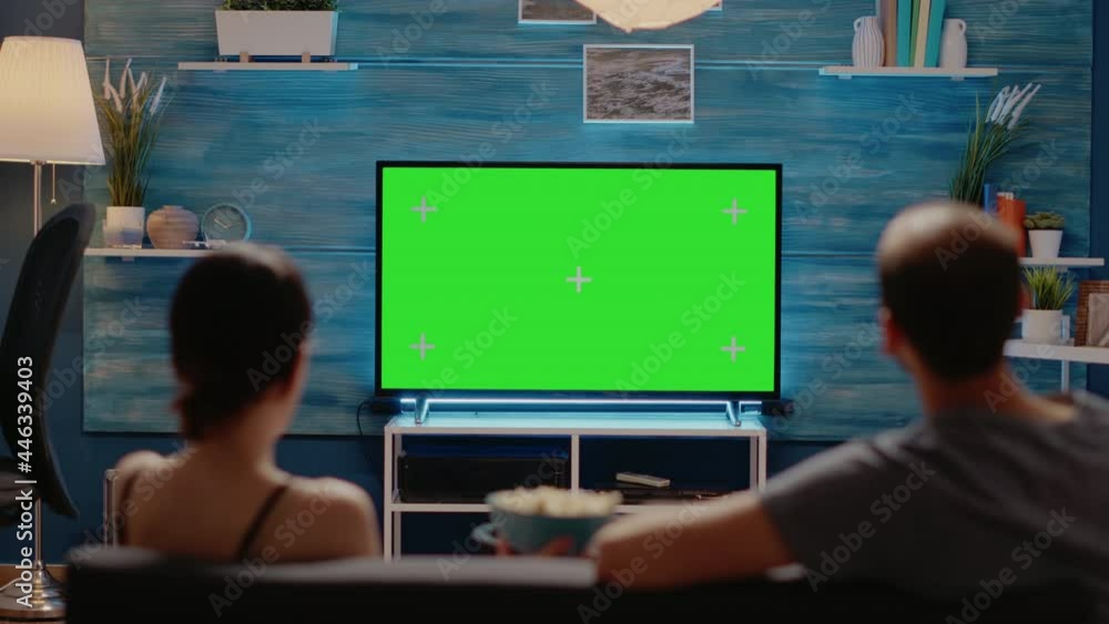 Young man and woman watching green screen on tv display sitting on ...