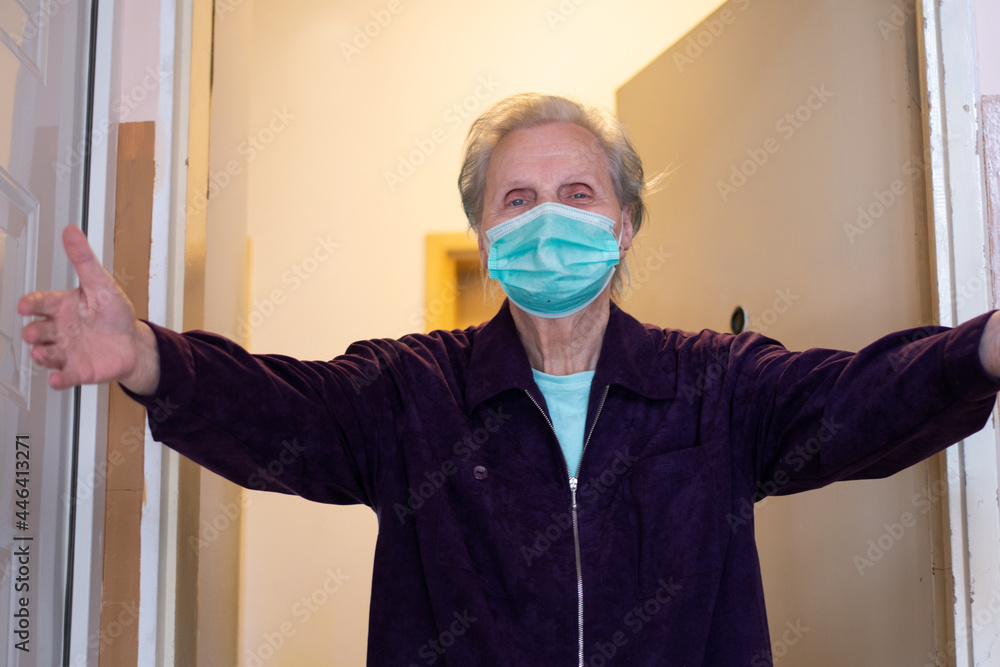 An old grandma standing in front of apartment waiting for her grandkids ...