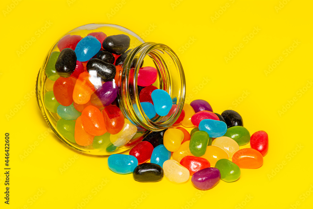 Jelly Bean Jar isolated on a bright yellow background, colorful candy ...