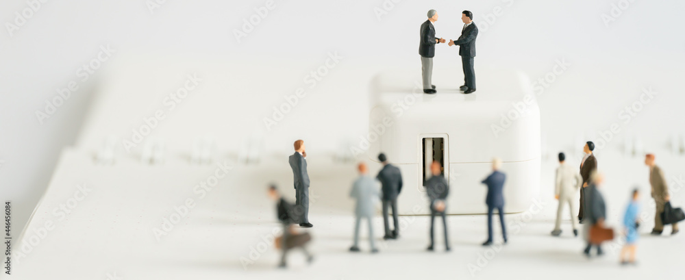 Miniature businessman shake hand partner client customers on stage with ...