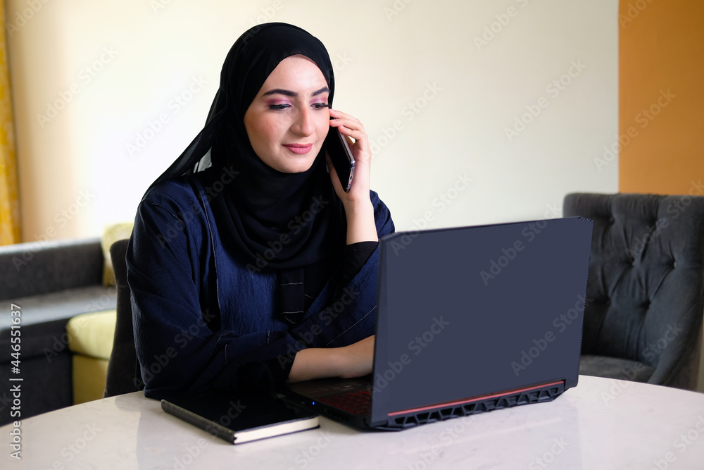 Arab working remotely from home. Emirati national at work. Woman ...