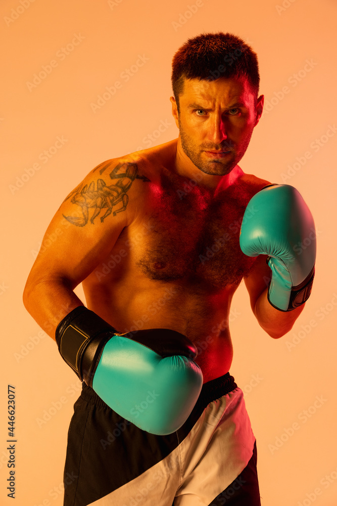 Close-up professional male boxer in sportswear and gloves isolated on ...
