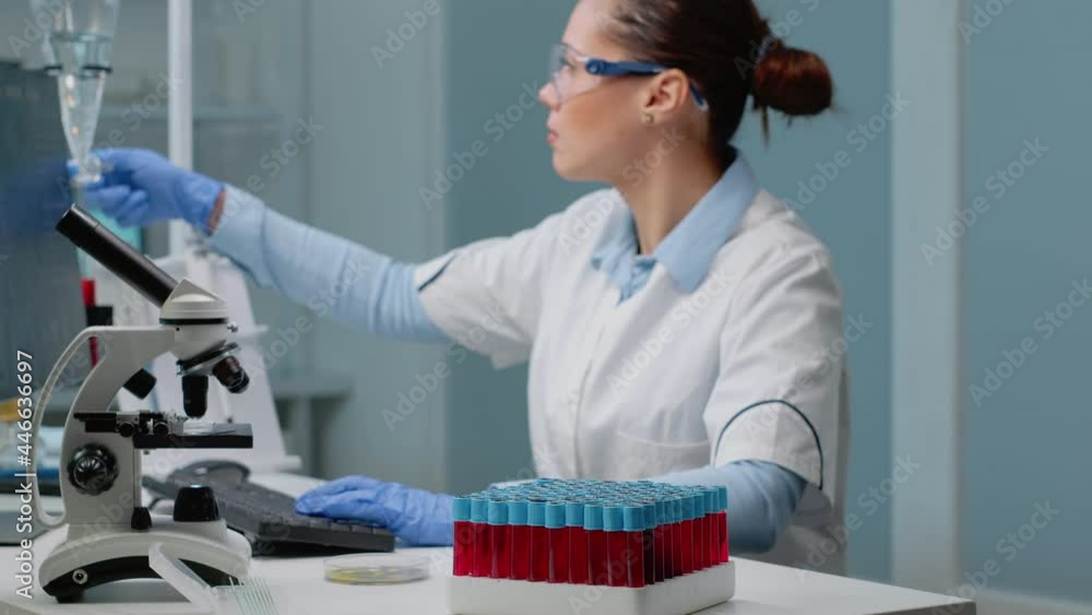 Video Stock Microbiology specialist using computer in laboratory while ...