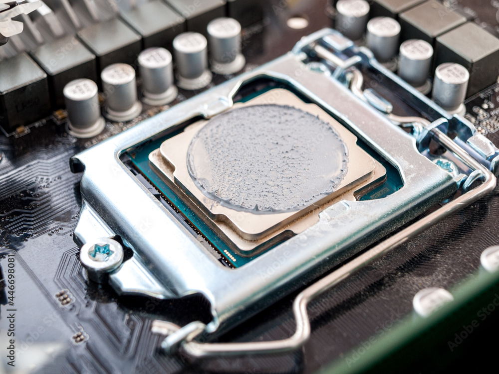 Applying a heat-conducting paste to the heat distributor, the cover of ...