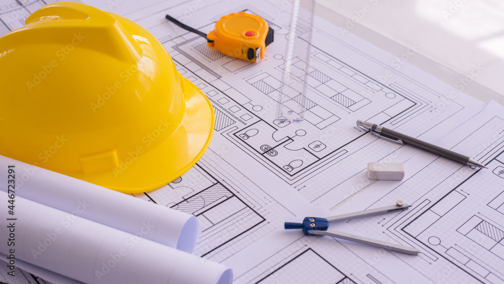 Yellow helmet and heap of drawing a project on a work desk. Project ...