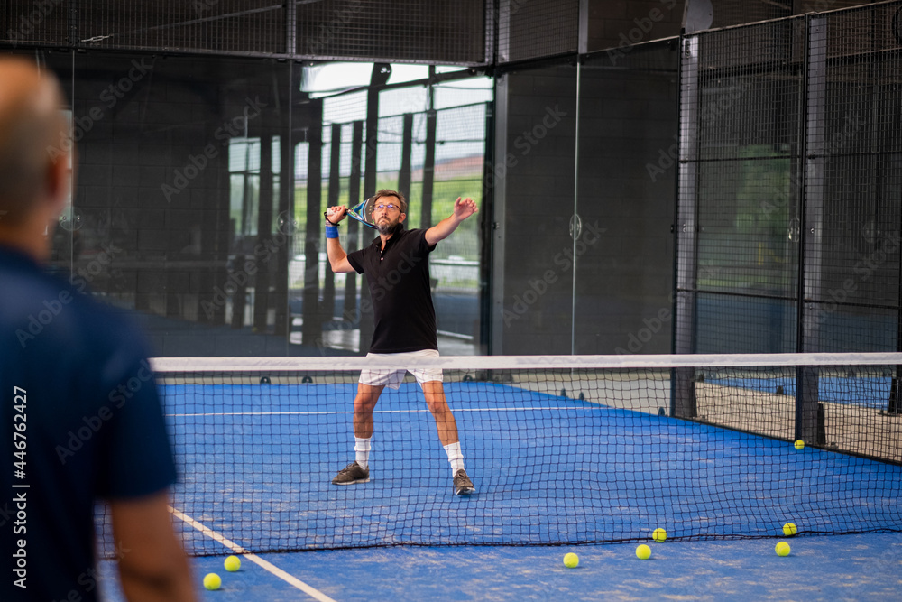 Monitor teaching padel class to man, his student - Trainer teaches boy ...