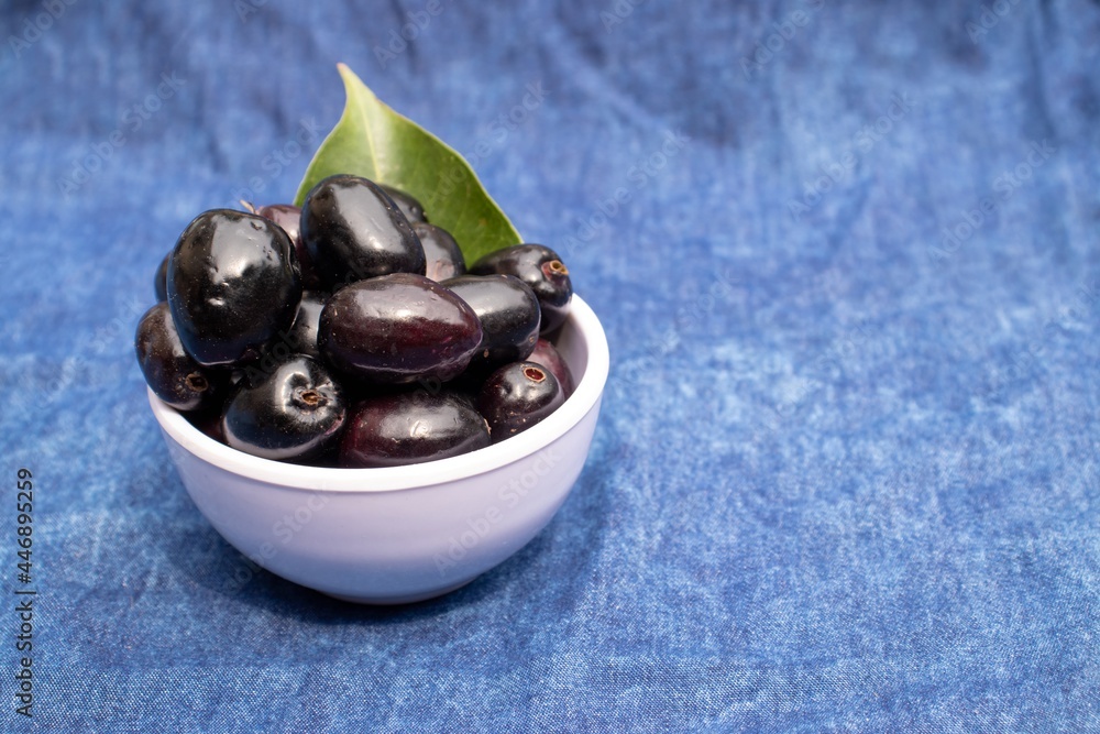 Organic Jamun or Black Plum in a Bowl Isolated on Blue Fabric ...