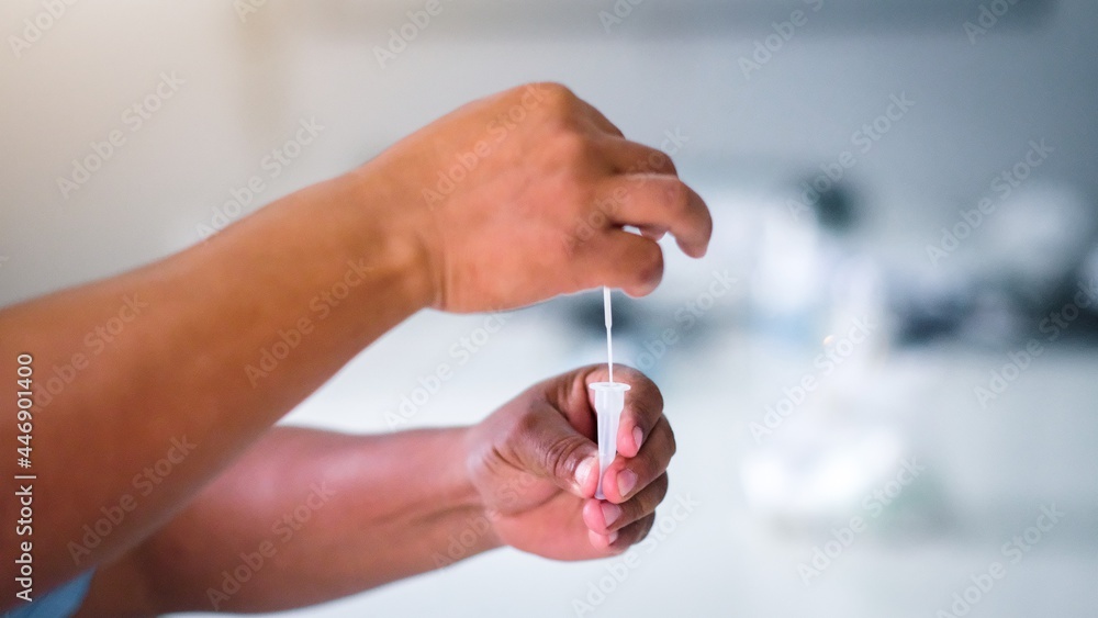 Fotografia do Stock: Man's hand drops secretions into antigen test kit ...
