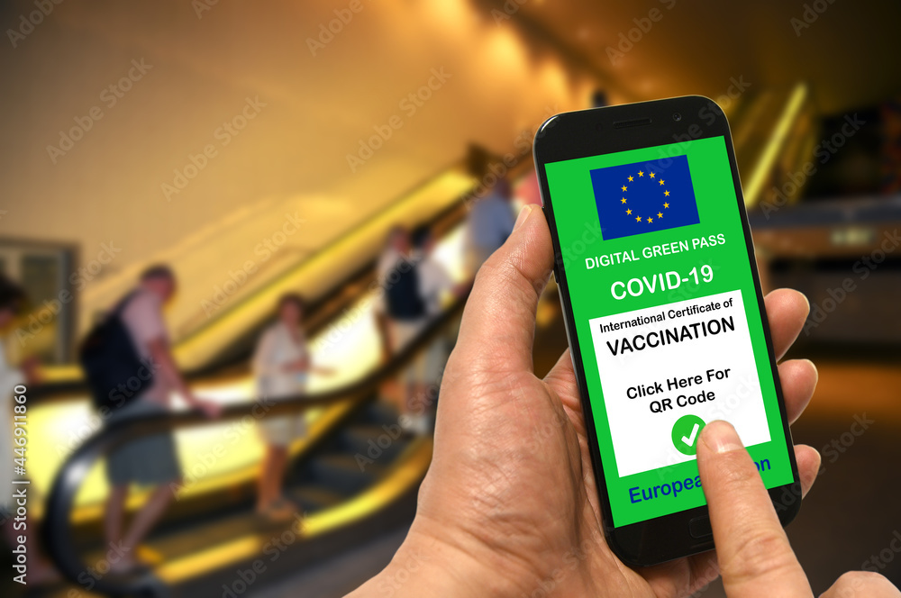 A man in a shopping mall holds a smartphone with the European Union ...