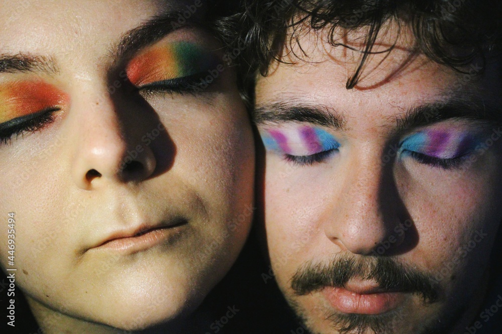 portrait of closeup faces of two lgbtq queer friends faces with rainbow ...