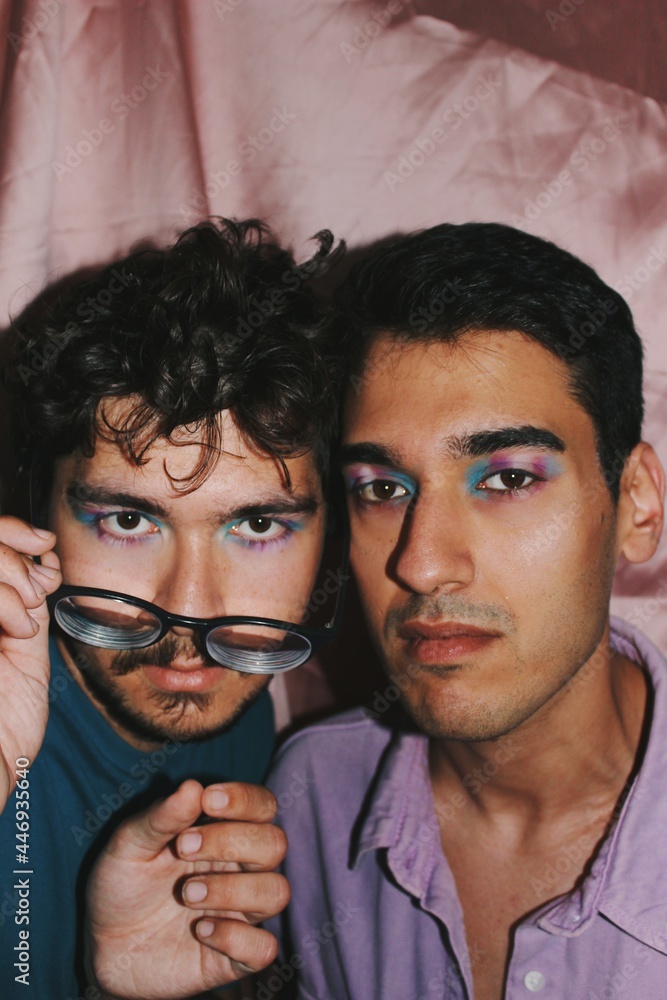 portrait of two queer young men with trans pride flag eye makeup and ...