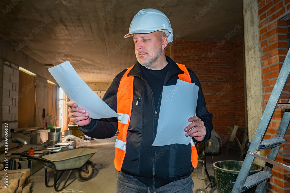 Foreman builder of builders examines a sheet of paper. Builder inside ...
